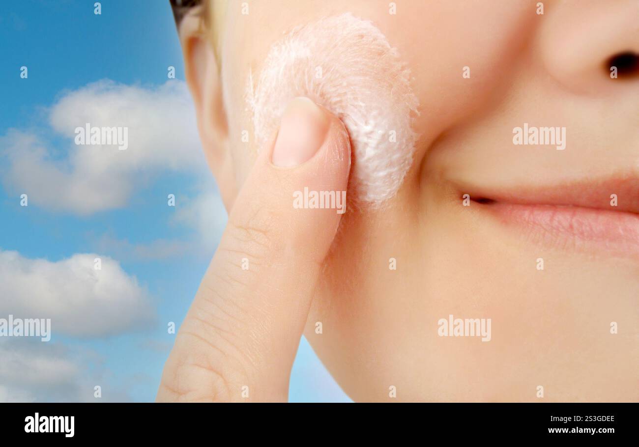 Fresh clean face being applied moisturizer on cheek with cloud ...