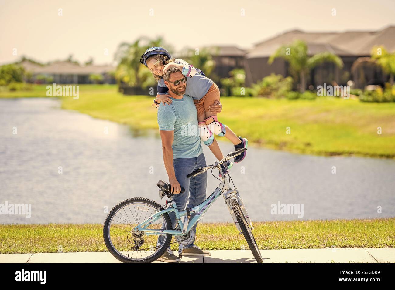 childhood of son supported by fathers care. father and son on bicycle ...