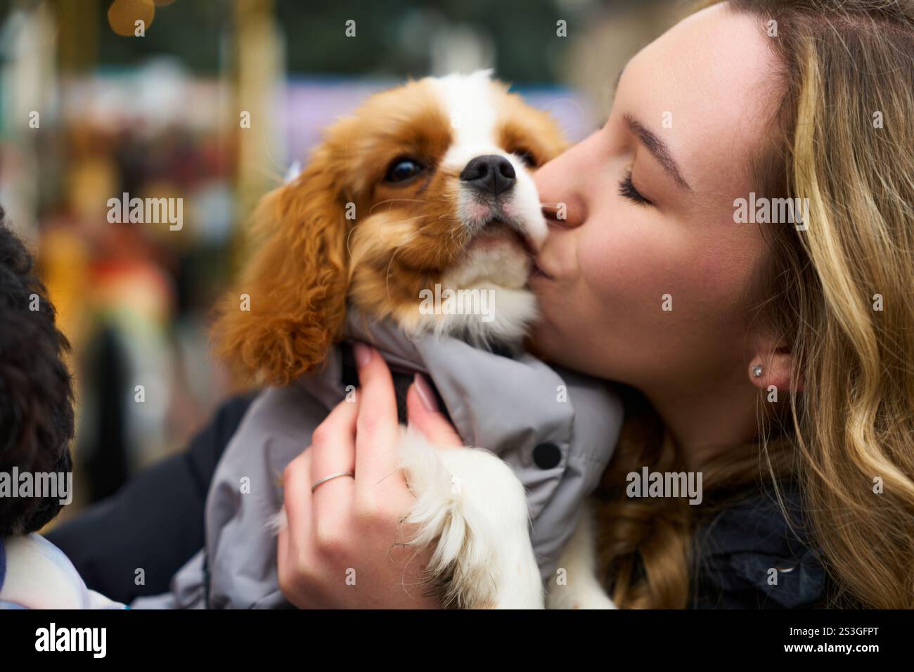 Joyful interaction between a woman and her dog at an outdoor fair ...