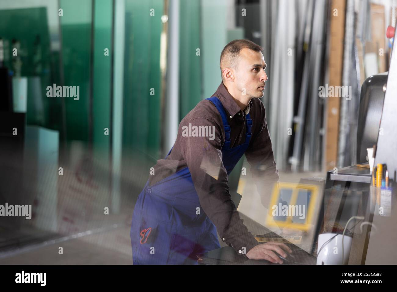Glass processing factory worker operating CNC machine Stock Photo - Alamy