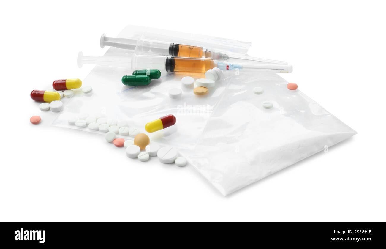 Drug addiction. Different pills, plastic bags with powder and syringes ...