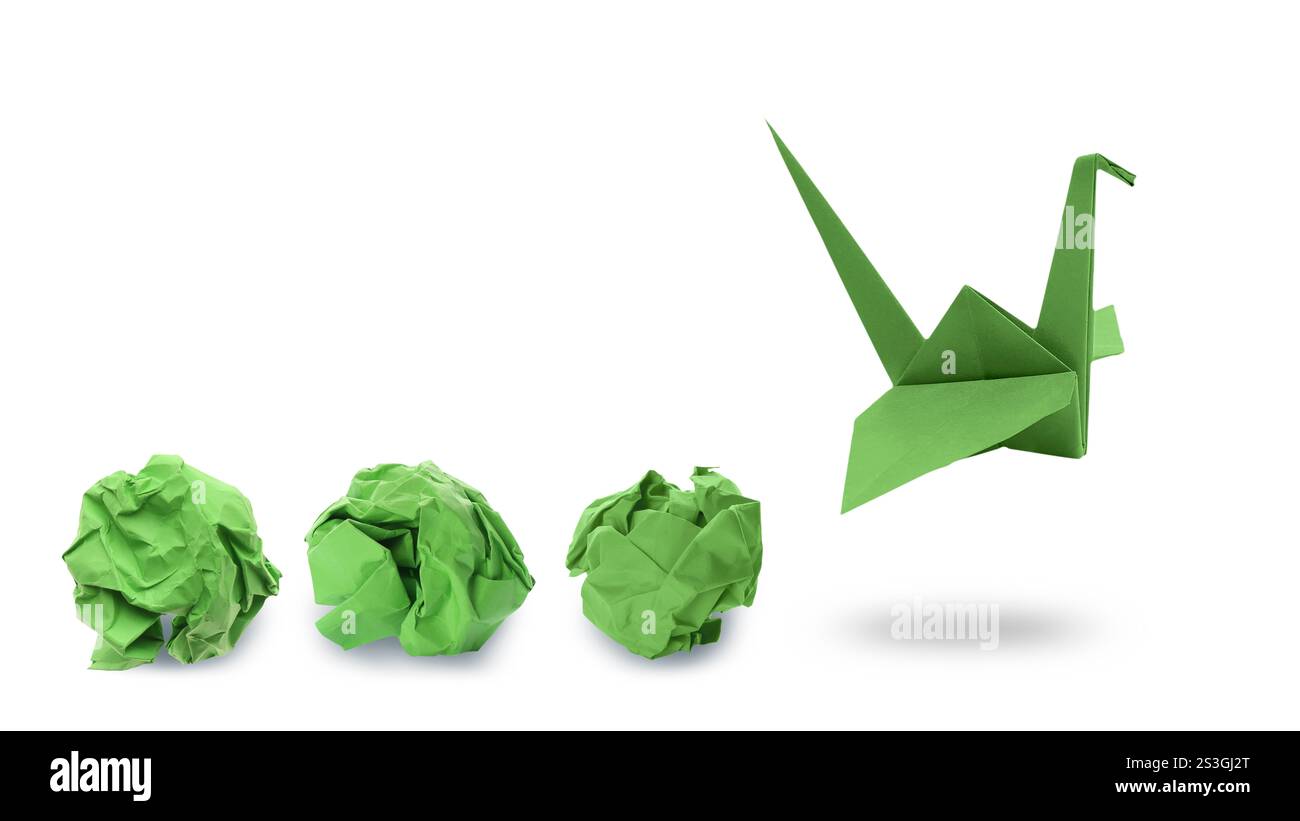 Green origami crane and crumpled paper balls on white background ...