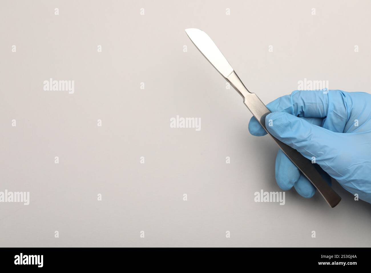 Doctor with surgical scalpel on light background, top view. Space for ...