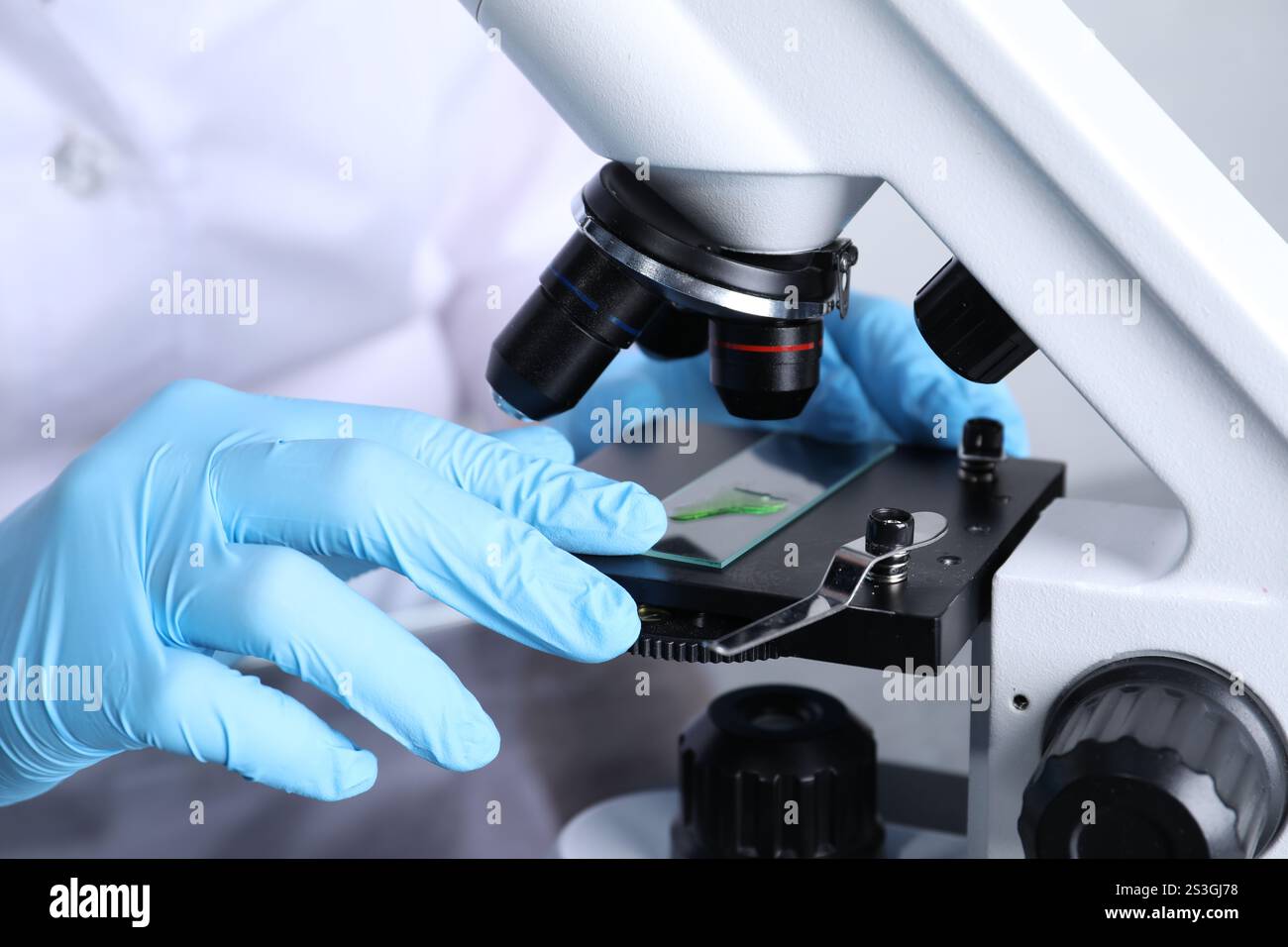 Laboratory testing. Scientist examining sample on slide under ...