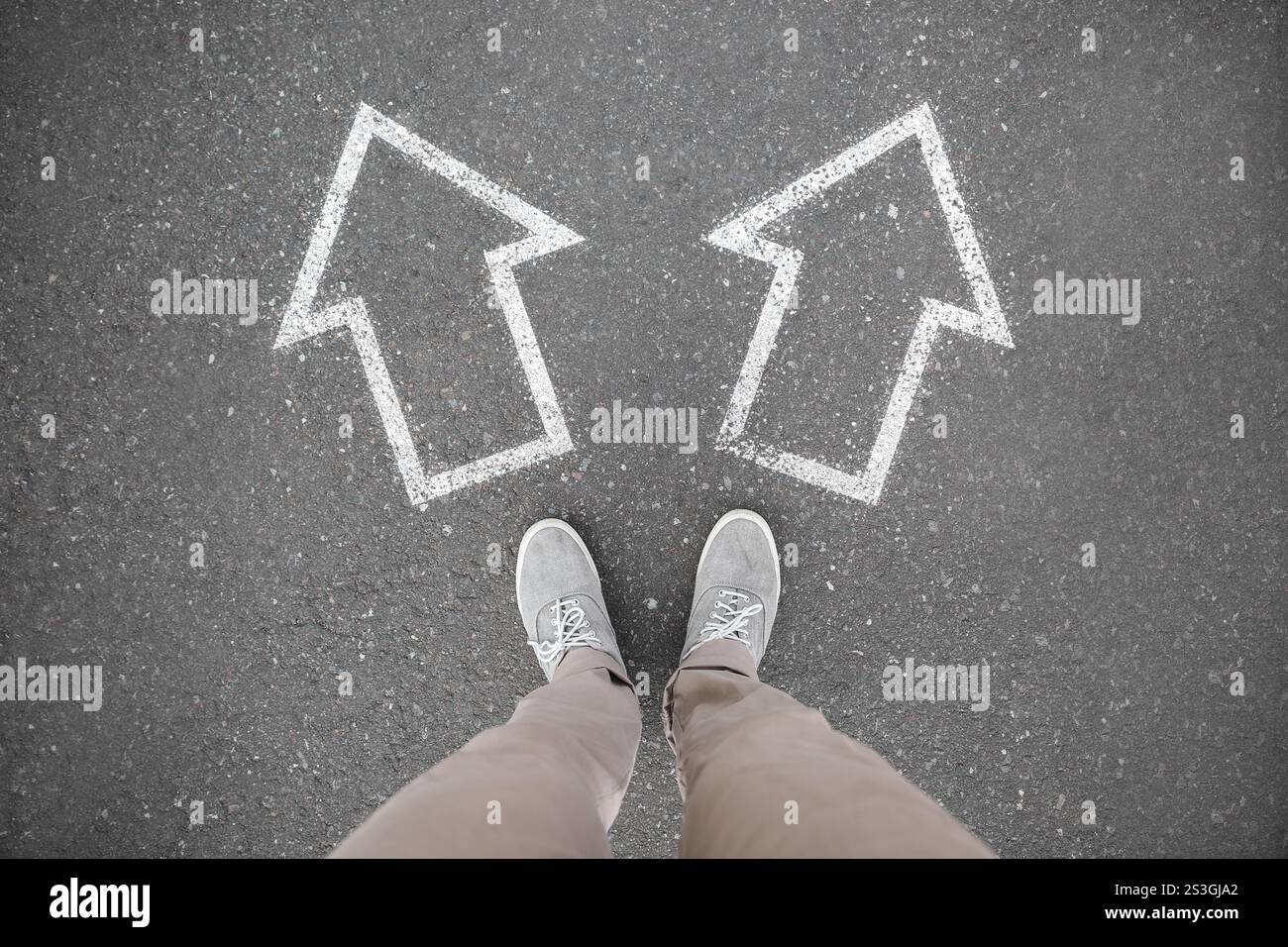 Man standing near white arrows pointing in different directions on ...