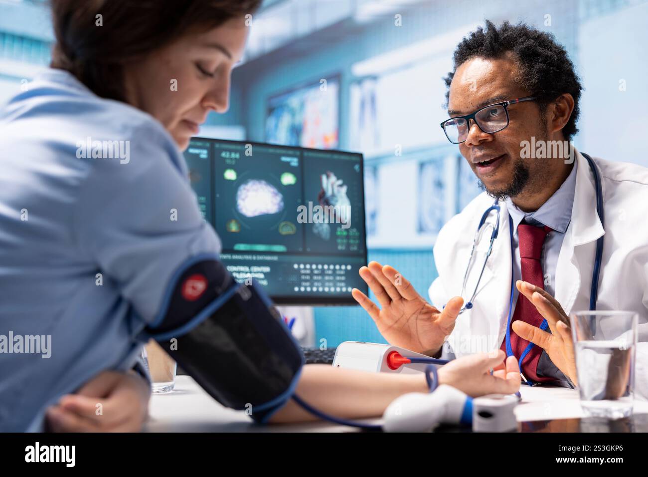 Physician using blood pressure monitor to check the pulse and blood ...