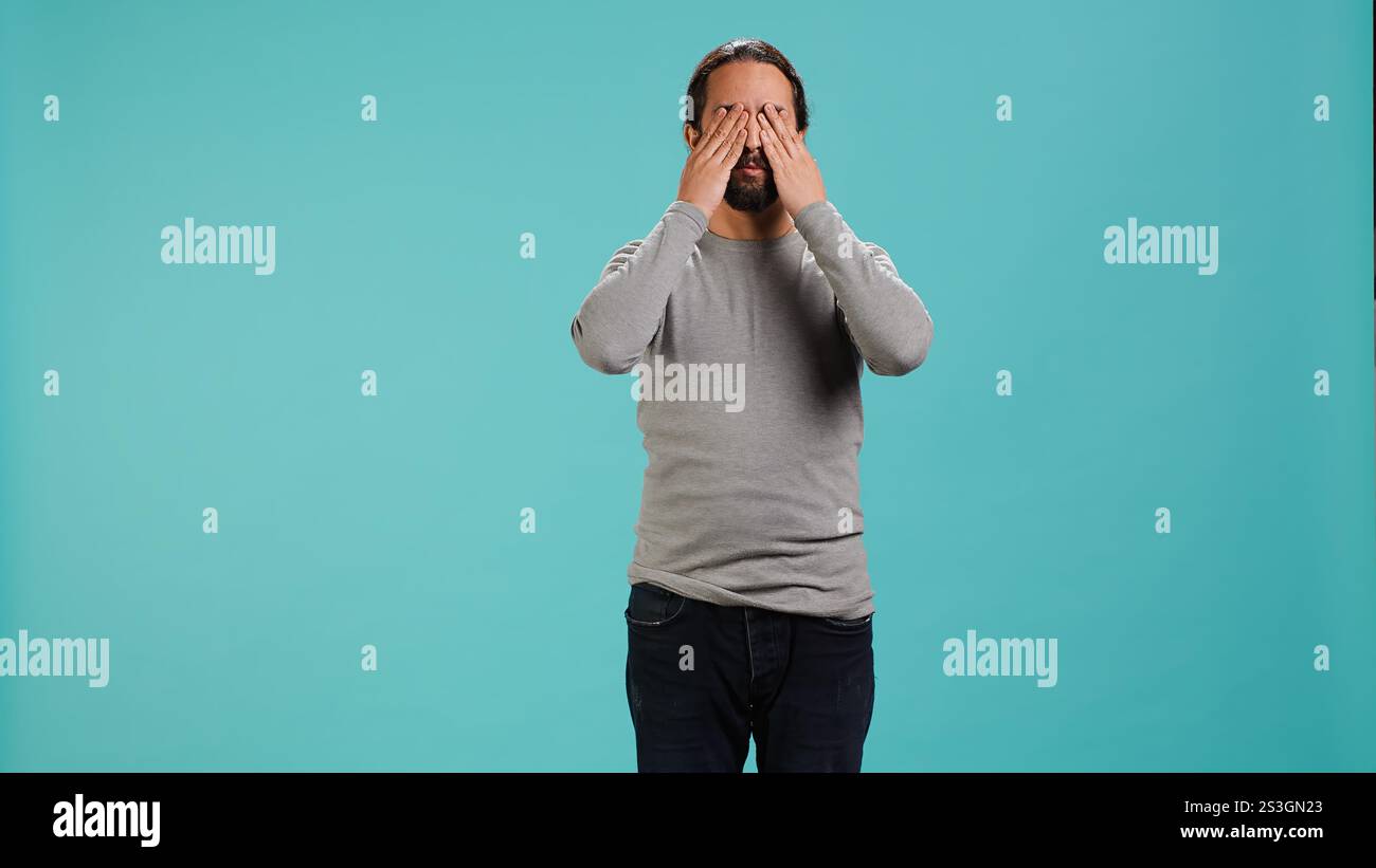 Man covering eyes, ears and mouth, imitating three wise monkeys. Arab ...