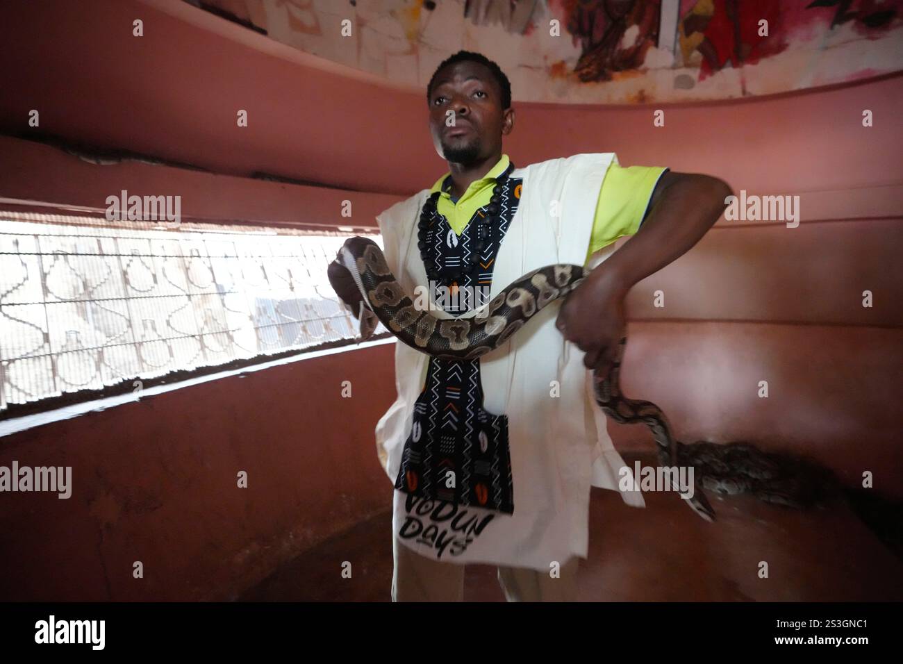 A guide at the Temple of Pythons, shows a python to a visitor at the ...