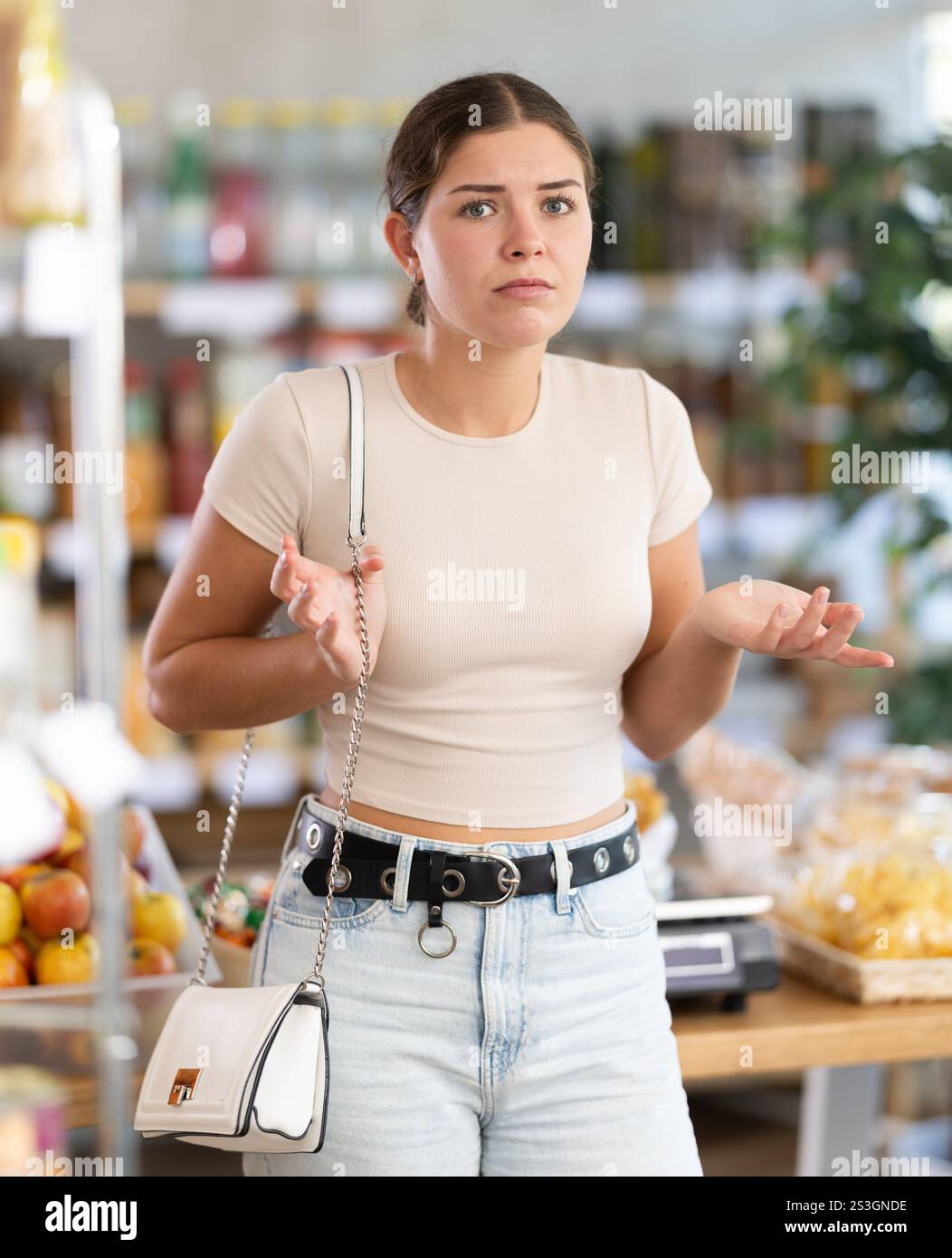 Girl customer suffer from forgetfulness, stand in store and tries to ...