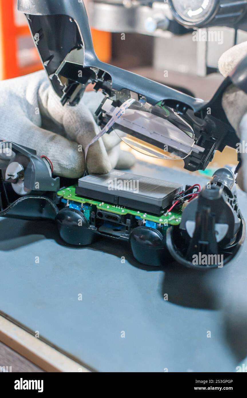 Hand with glove plugging some connection from a video game controller ...