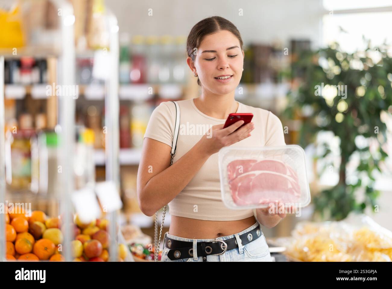 Girl scan QR-code on raw beef tenderloin package in store Stock Photo ...