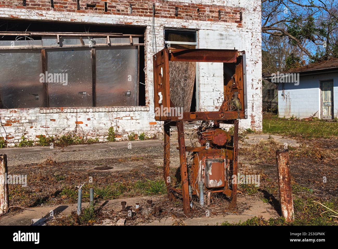 An old rusted gas pump falling apart in front of an abandoned old gas ...