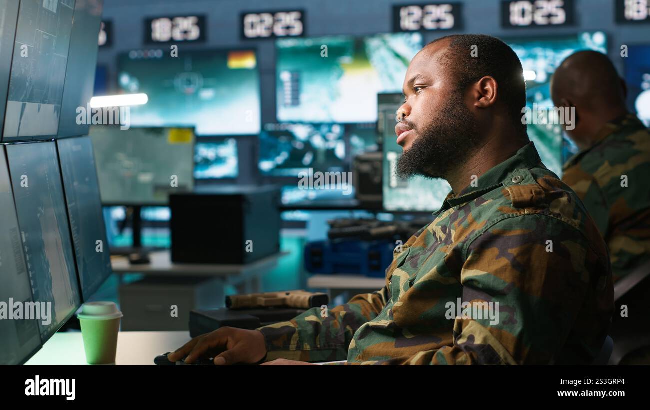 Military agent working overtime in control room to analyze aerial ...