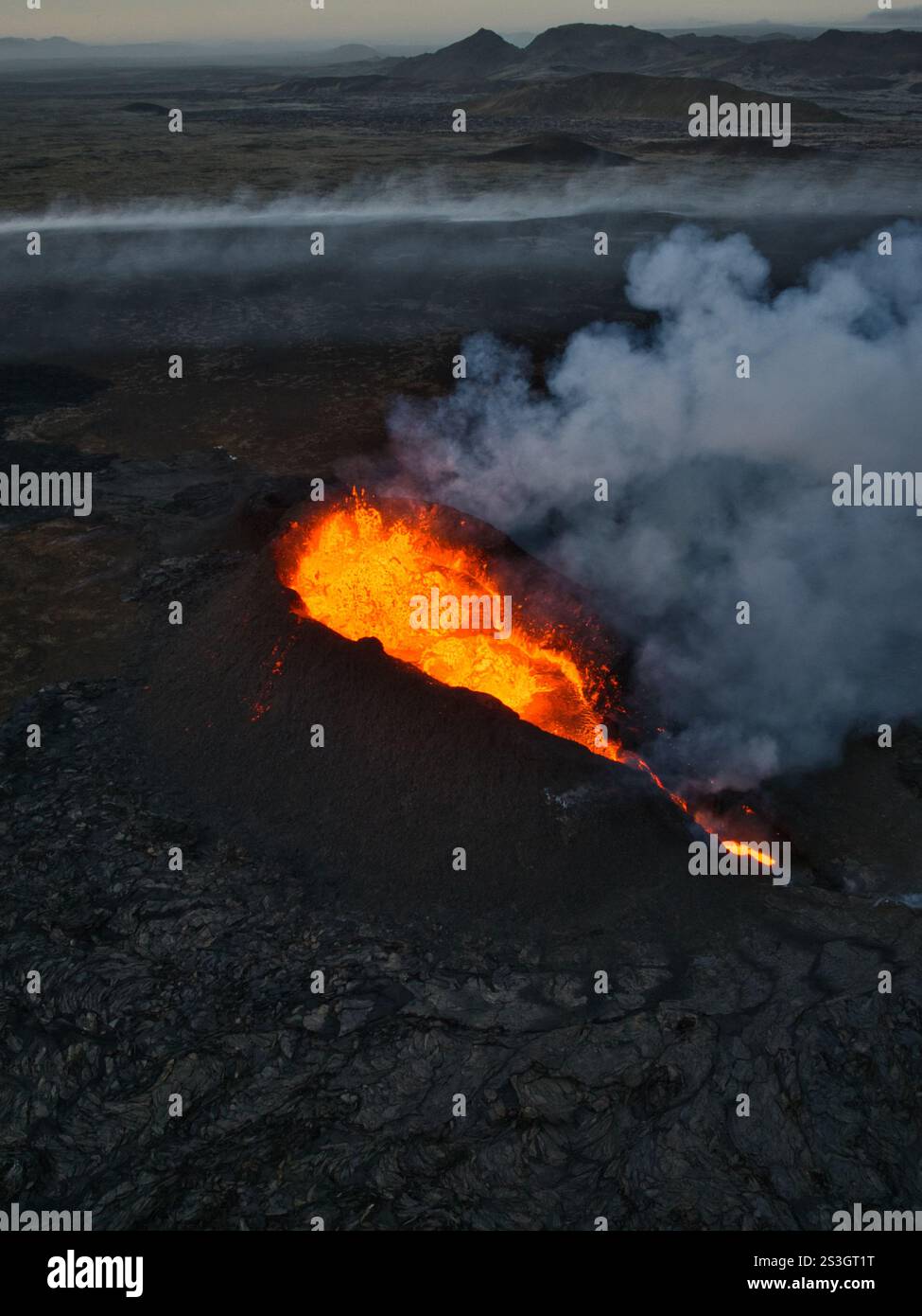Aerial view of an erupting volcano in Iceland, featuring glowing molten ...
