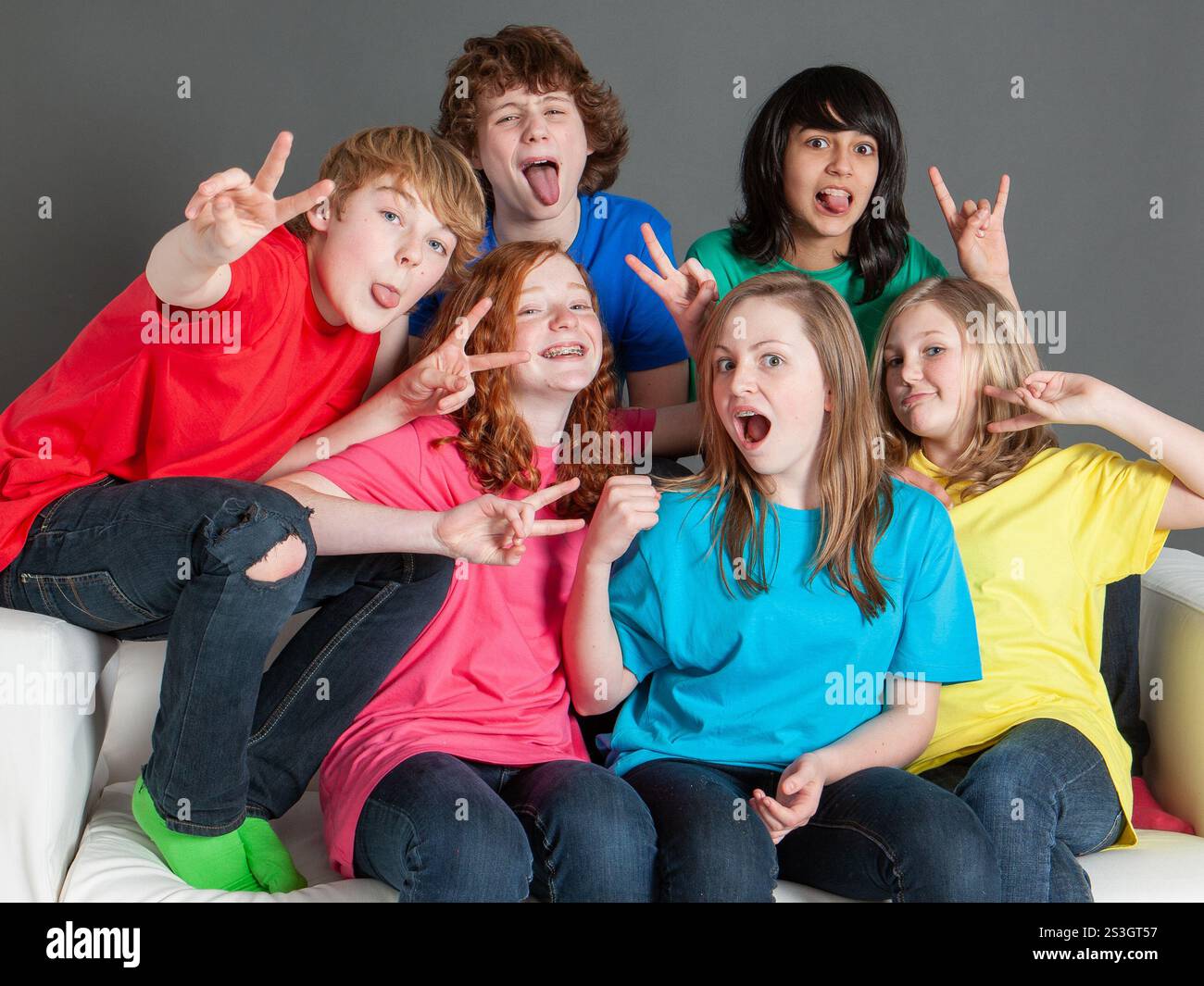 Portrait of a relaxed group of early teenage friends messing about for ...