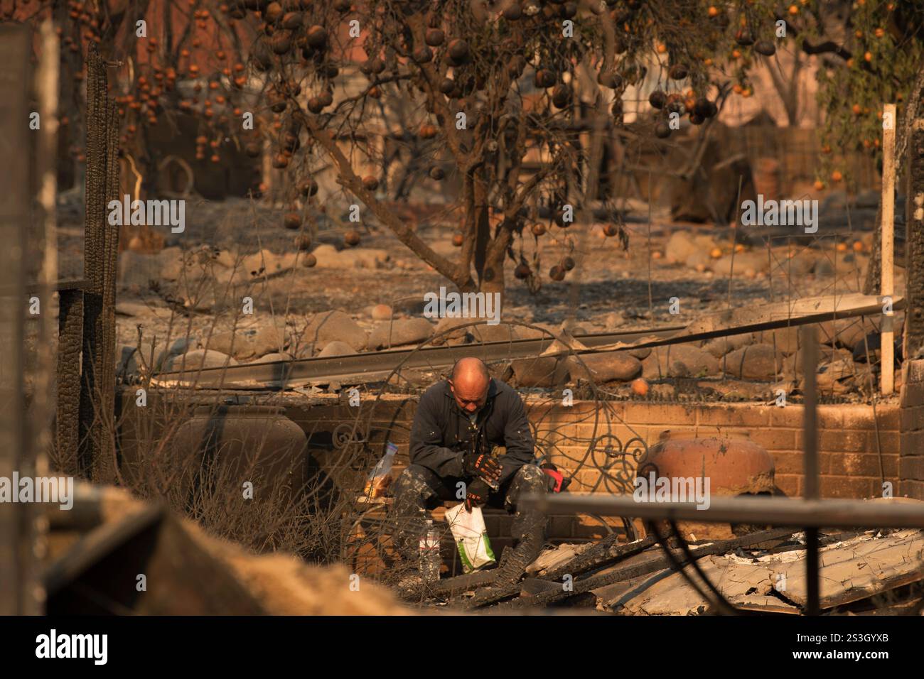 Cesar Plaza becomes emotional while sitting among the remains of his ...