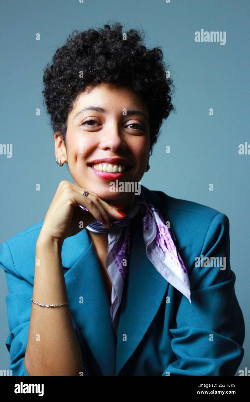 Successful businesswoman smiling brightly at camera, with chin on her ...
