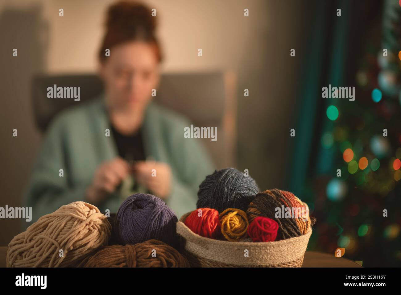 A colorful basket of yarn takes center stage, with a blurred young ...