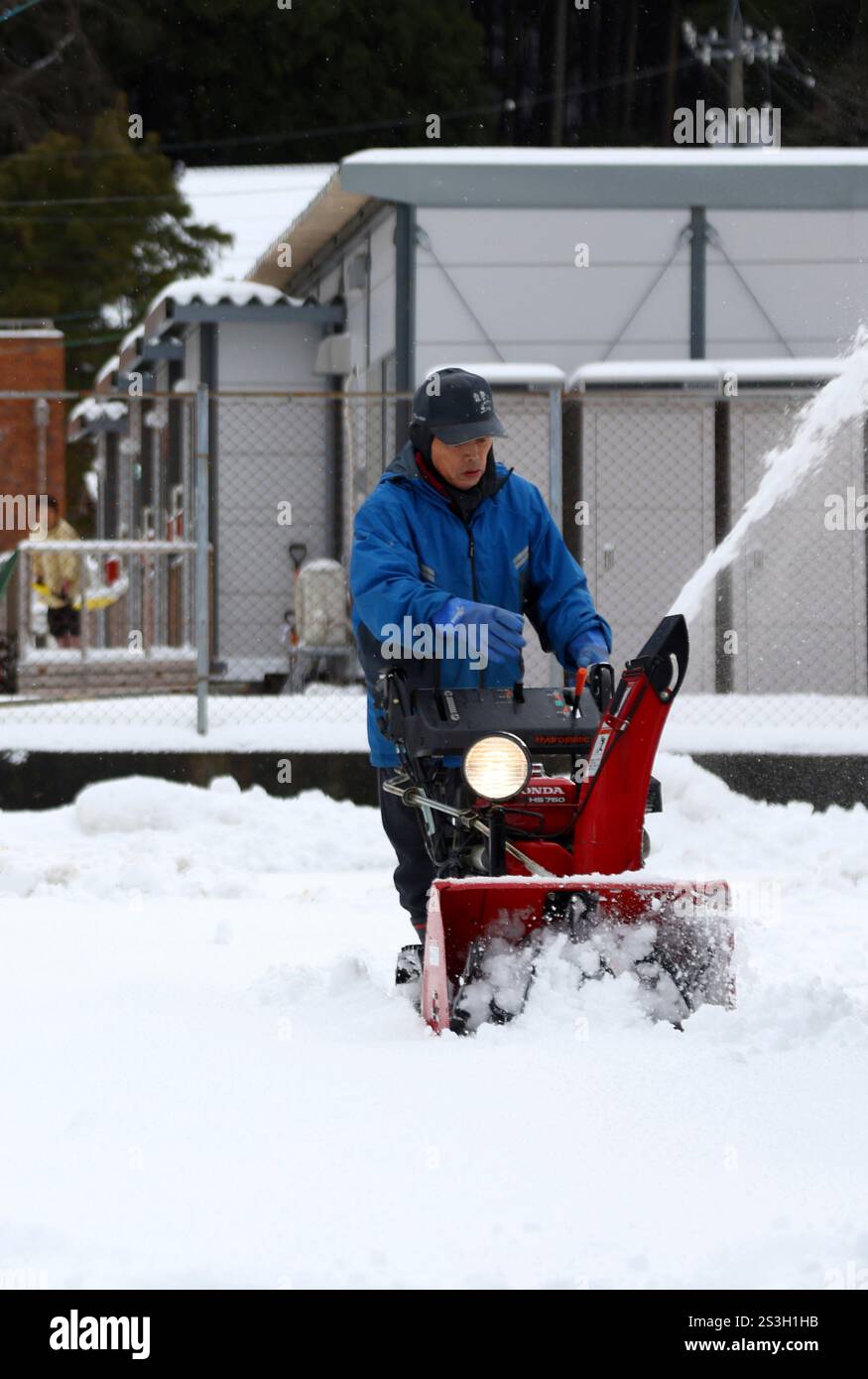 A man removes snow at a temporary house area in Wajima City, Ishikawa ...