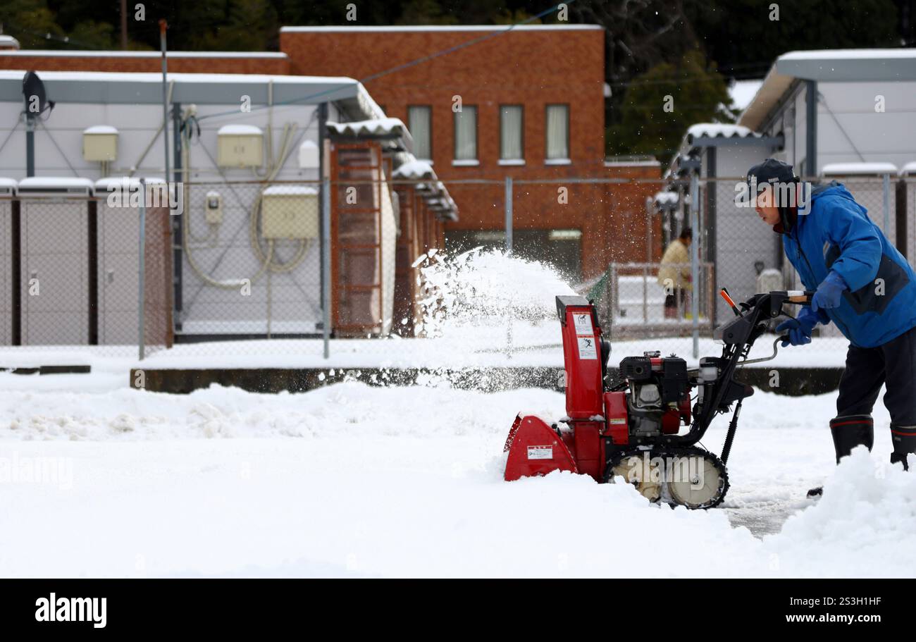 A man removes snow at a temporary house area in Wajima City, Ishikawa ...