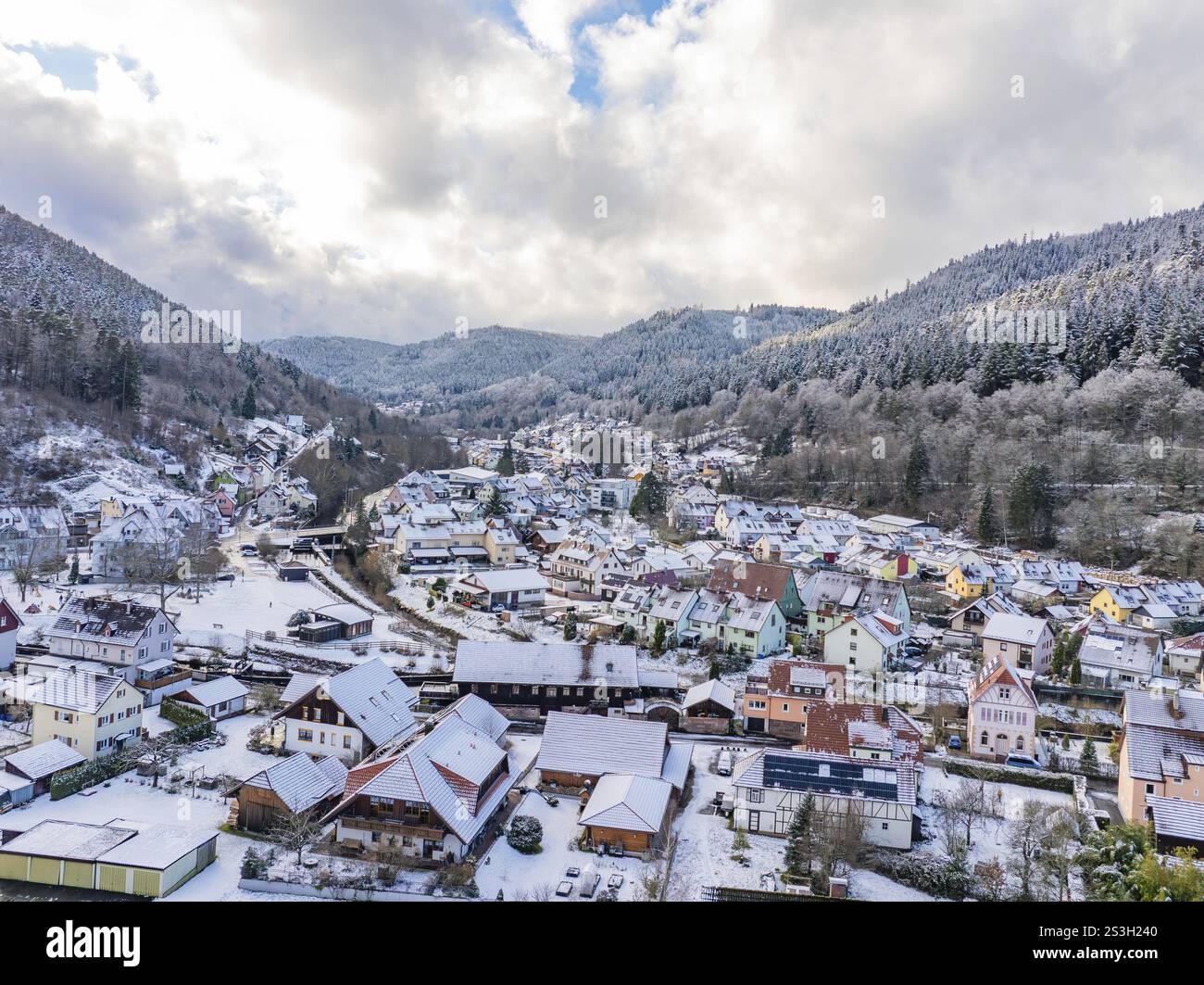 Snow-covered town with colourful houses embedded in a wintry mountain ...