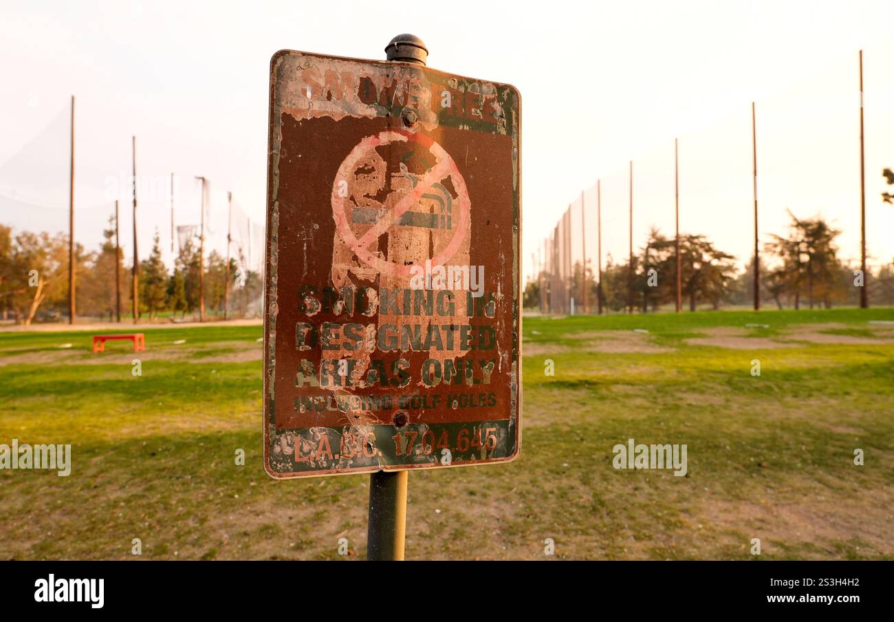A charred sign stands outside the driving range of the Altadena Golf ...
