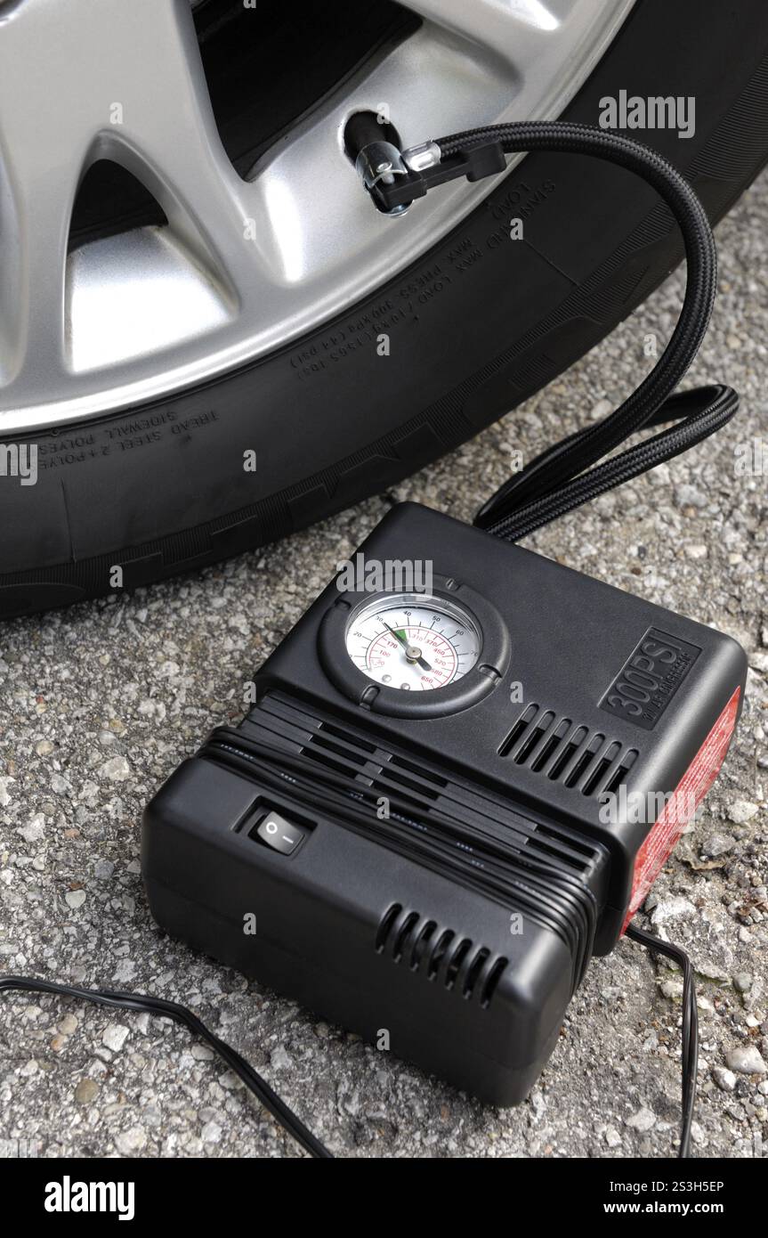Inflating a car tire with air compressor Stock Photo - Alamy