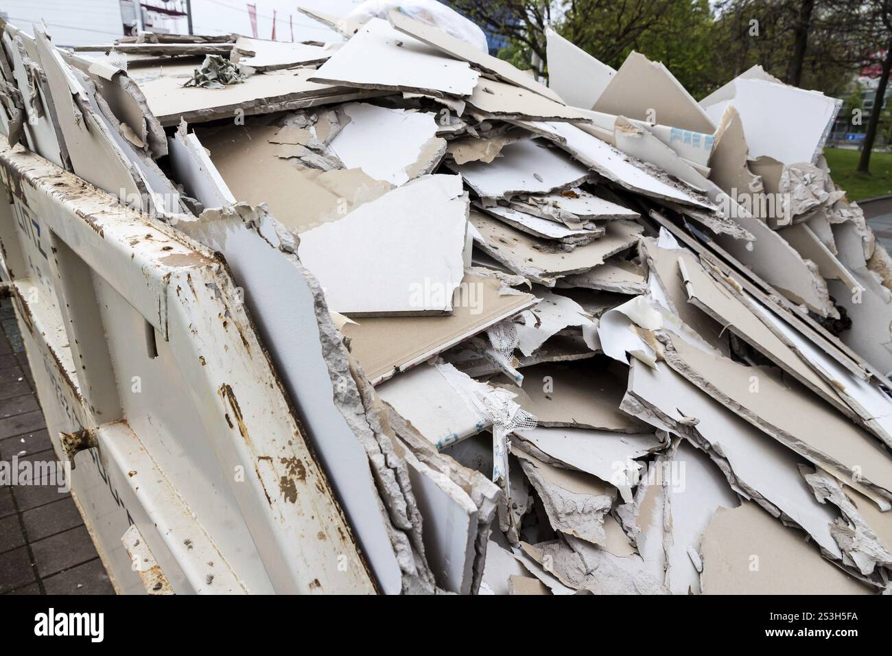 Plasterboard sheets are stored in a waste container for disposal ...