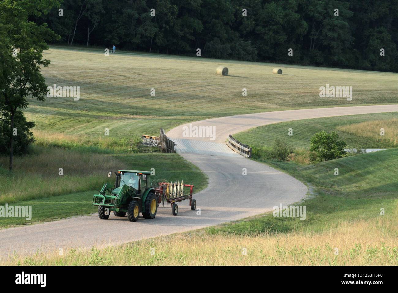 Forest, Virginia, USA. A tractor with hay rake on the road through ...