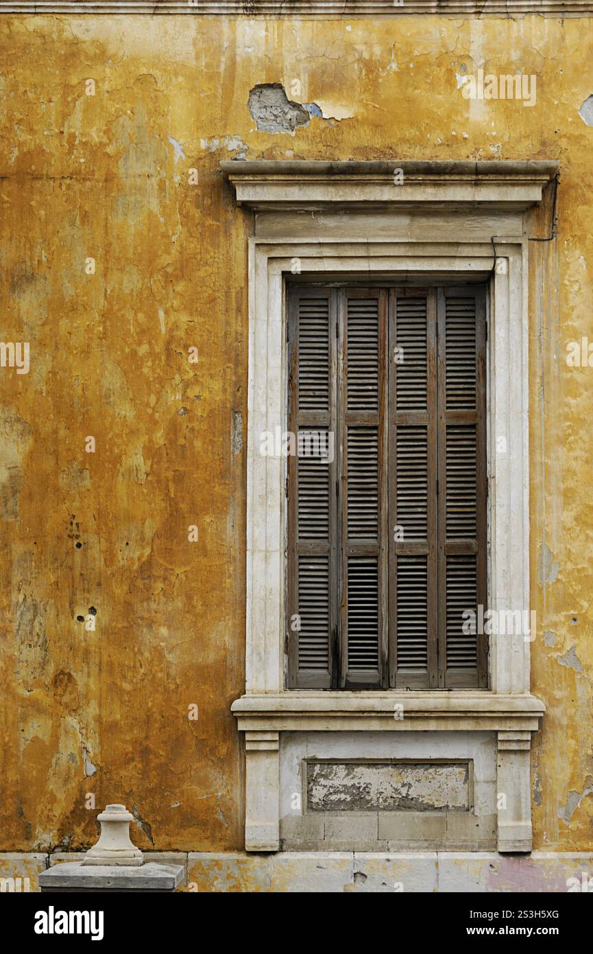 Stock photo of an Old shuttered wooden window in a yellow wall with ...