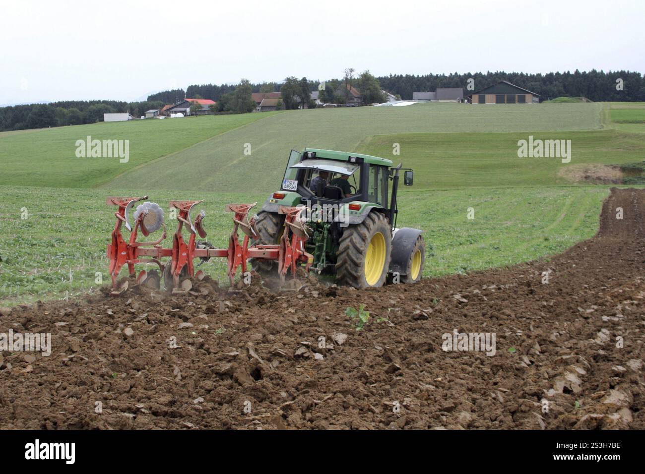 Bauer ploughs a field with his tractor Stock Photo - Alamy