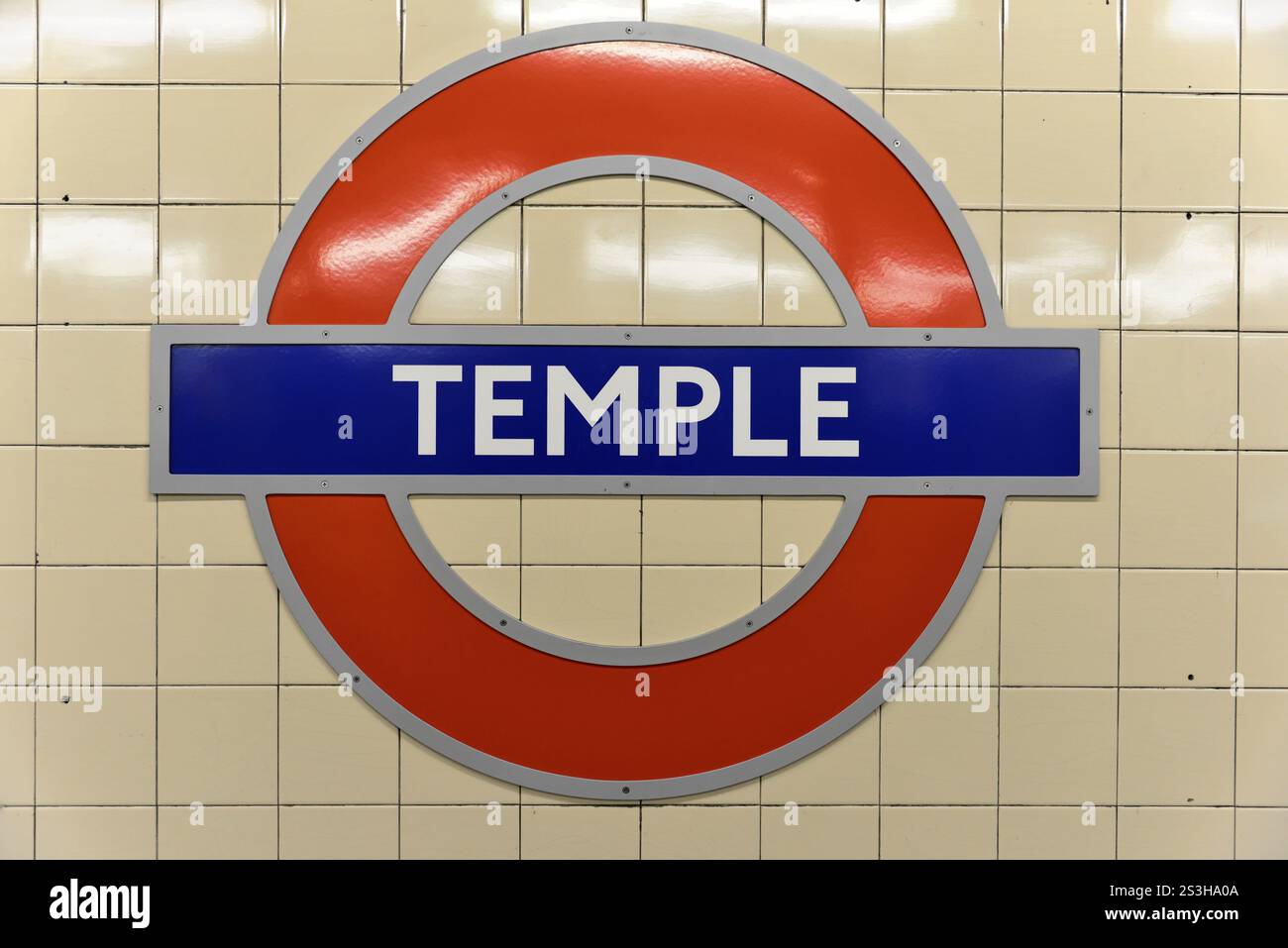 The red and blue Tube logo of Temple Station on a tiled background ...