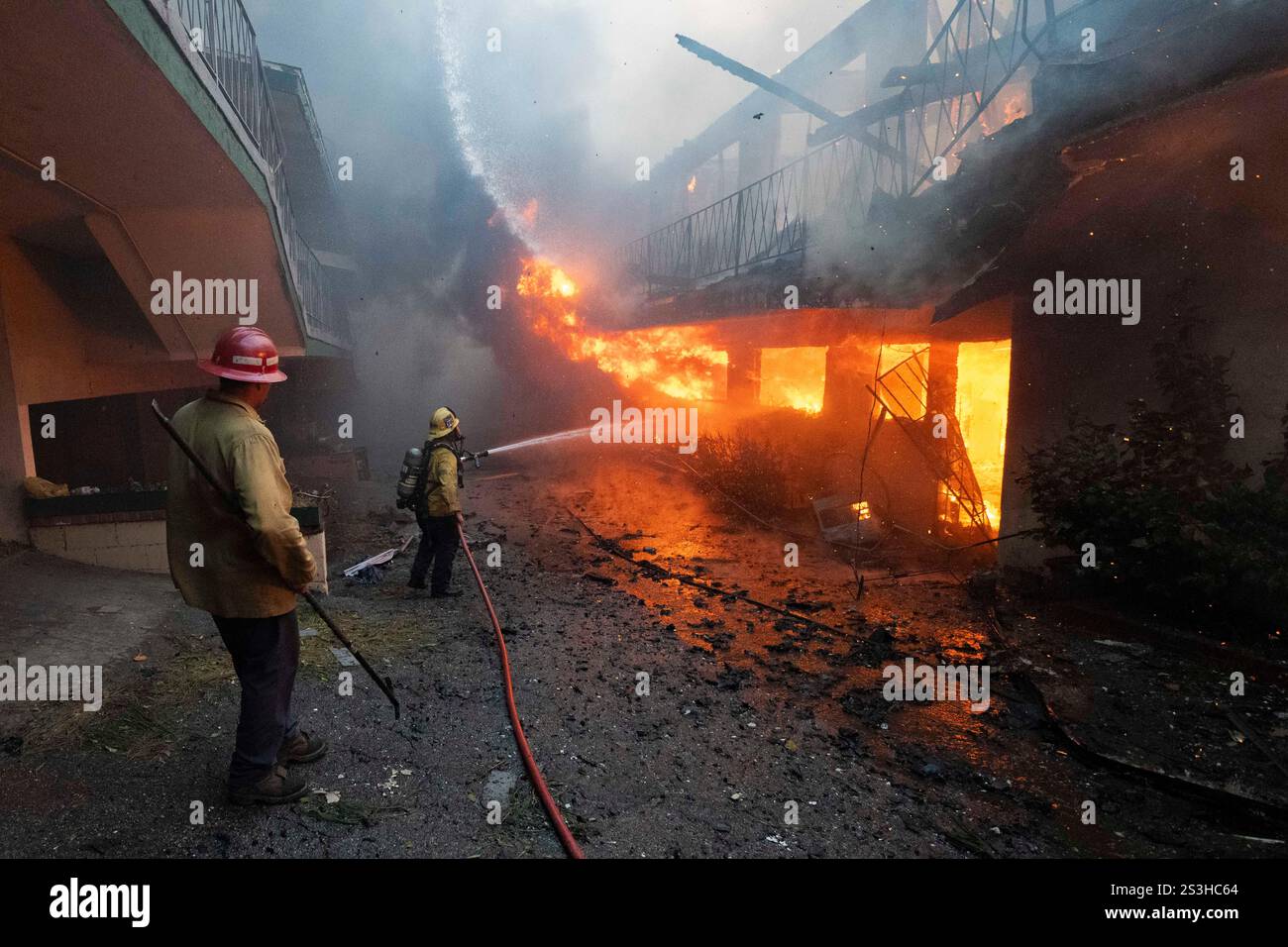 Long Beach FD Firefighter hoses down a burning apartment building. The ...