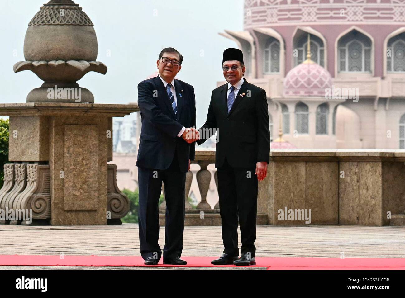 Malaysia's Prime Minister Anwar Ibrahim, right, shakes hands with Japan ...