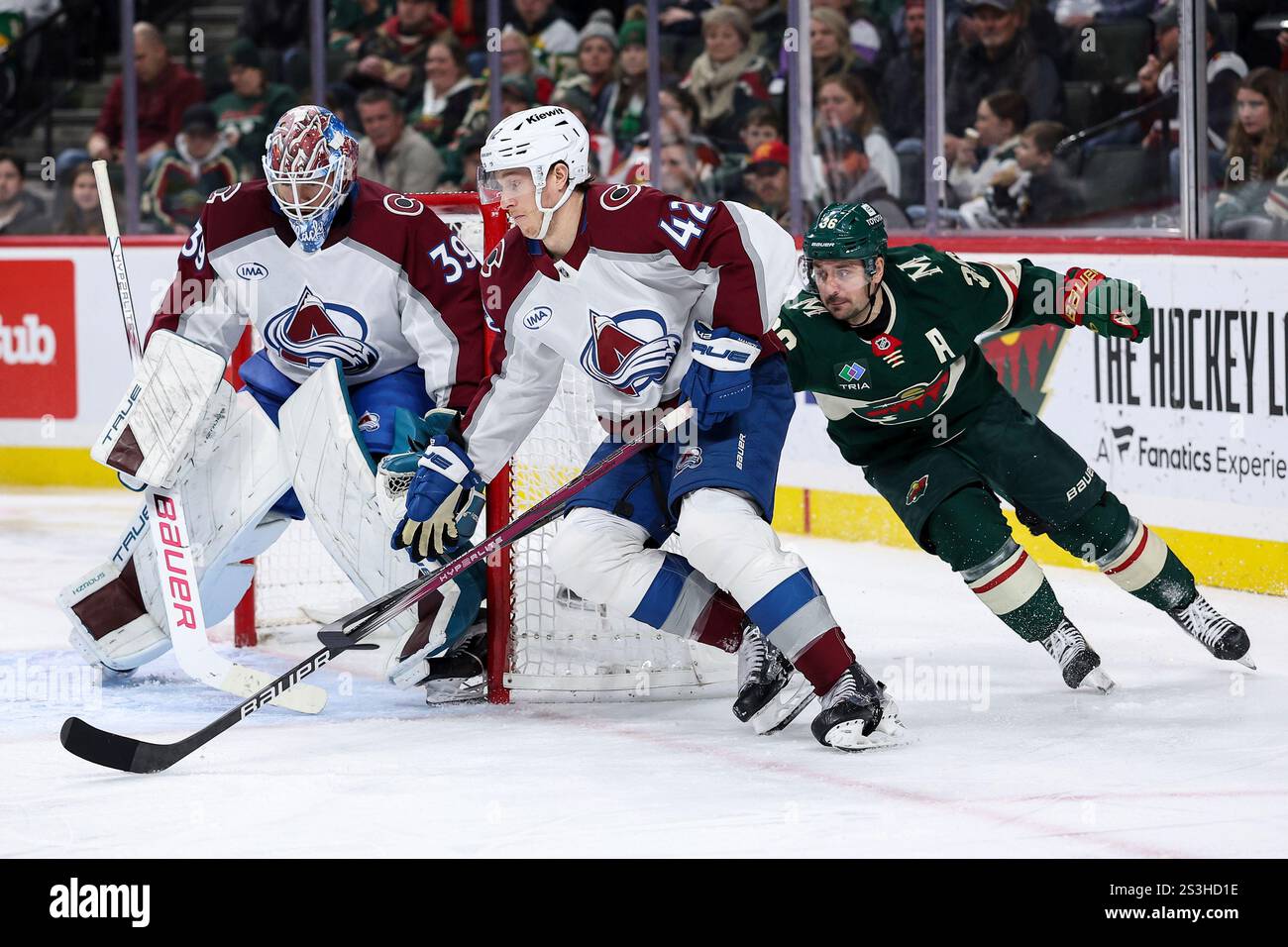 Colorado Avalanche defenseman Josh Manson, center, skates with the puck ...