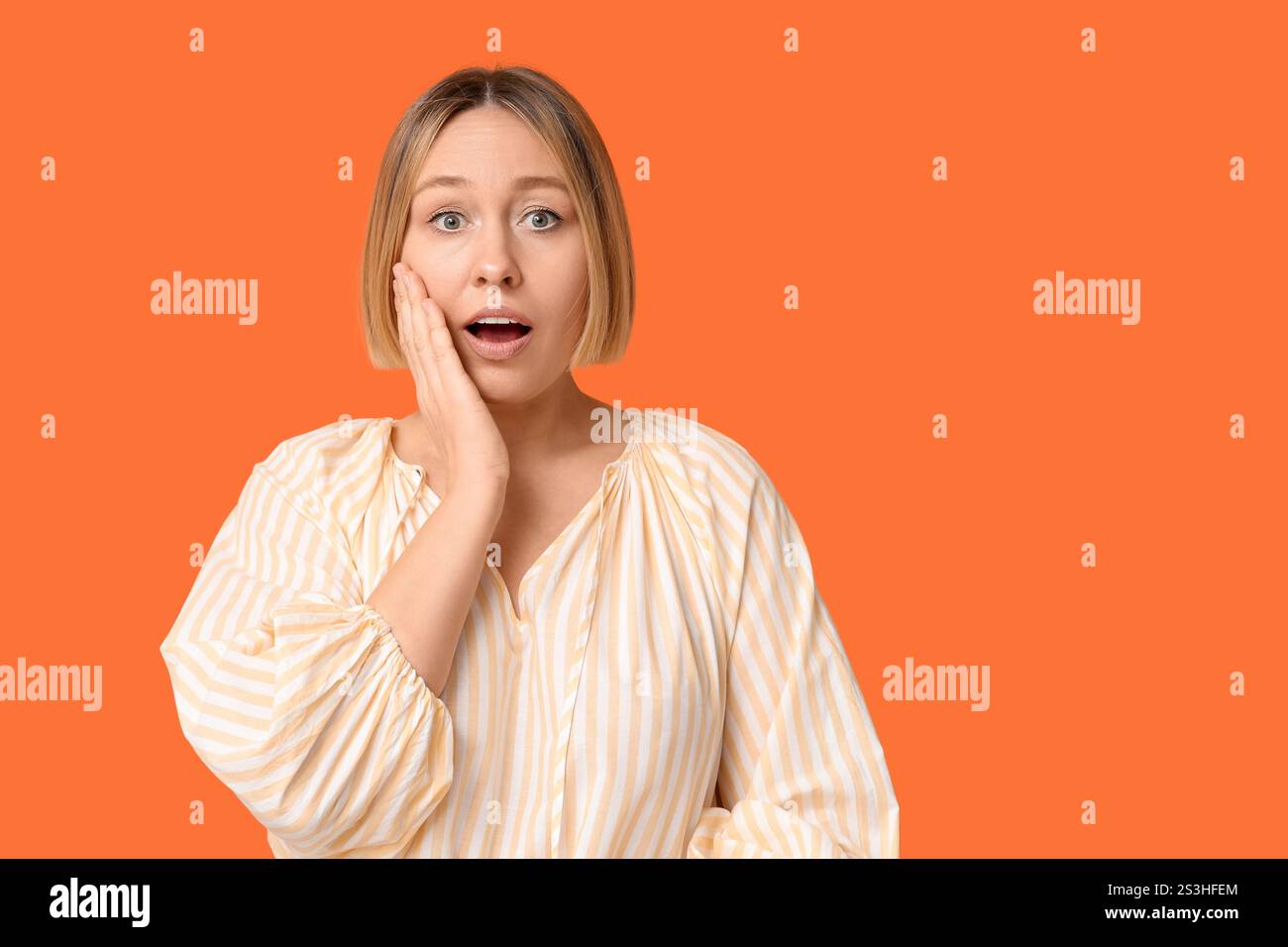 Shocked adult woman on orange background Stock Photo - Alamy