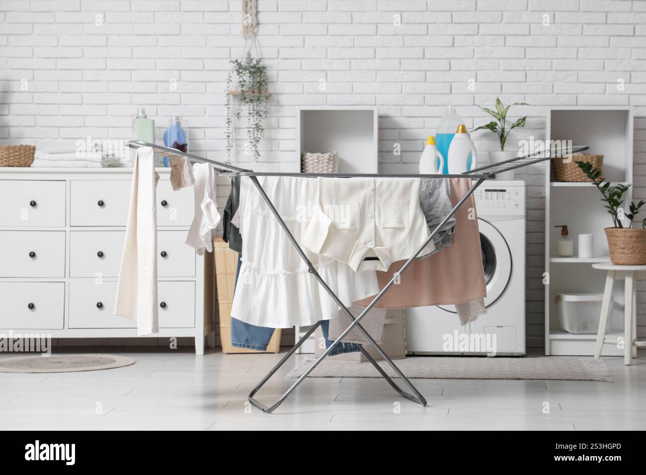 Dryer with clean clothes in light laundry room Stock Photo - Alamy