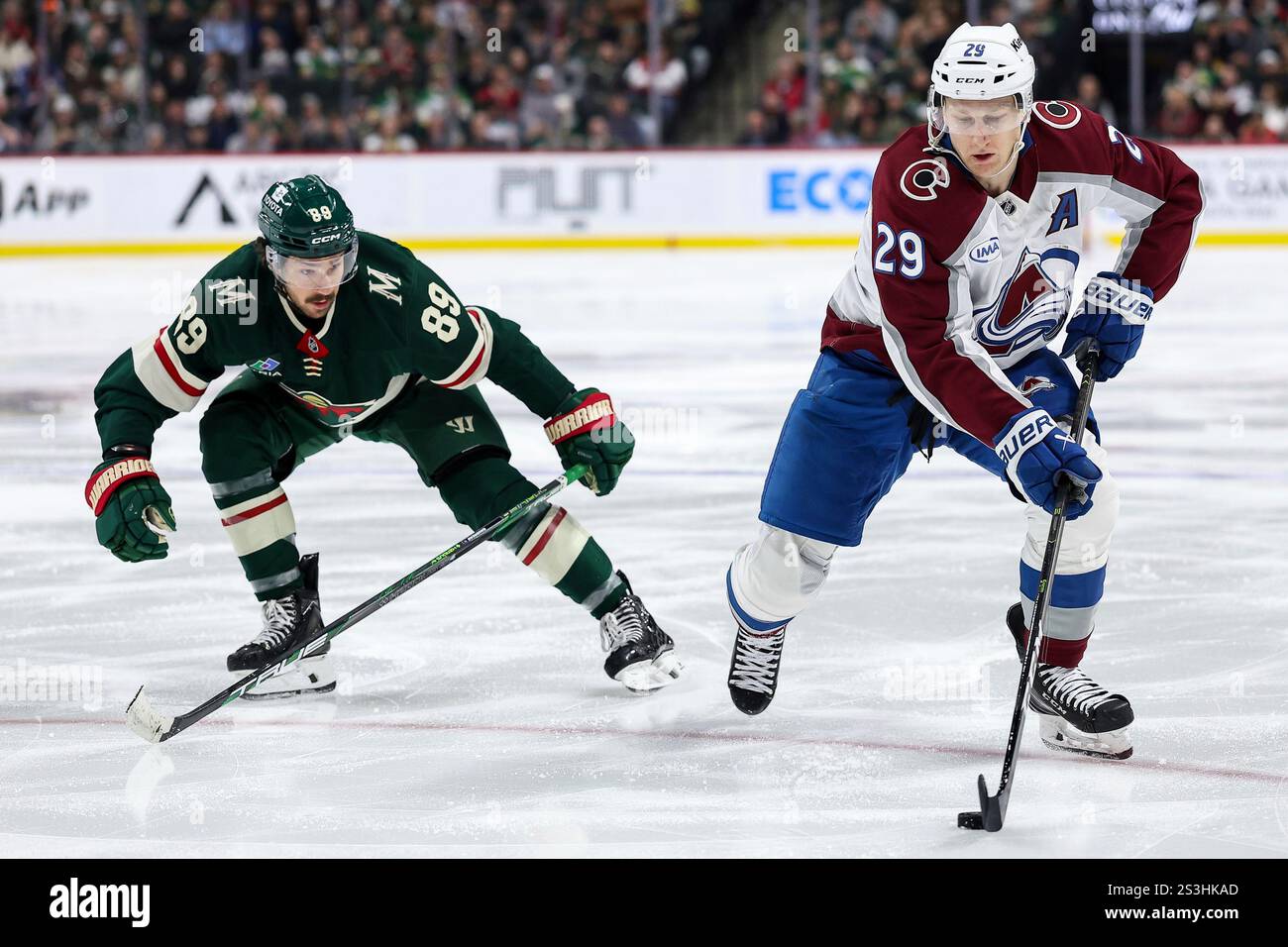 Colorado Avalanche center Nathan MacKinnon, right, skates with the puck ...