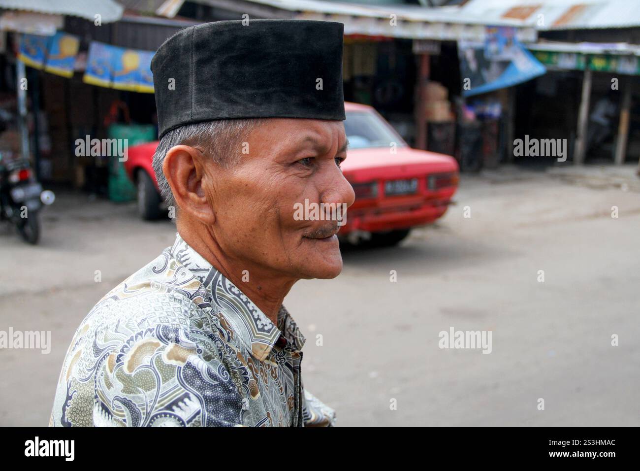 An elderly Minangkabau man with a goatee and white hair wearing a peci ...