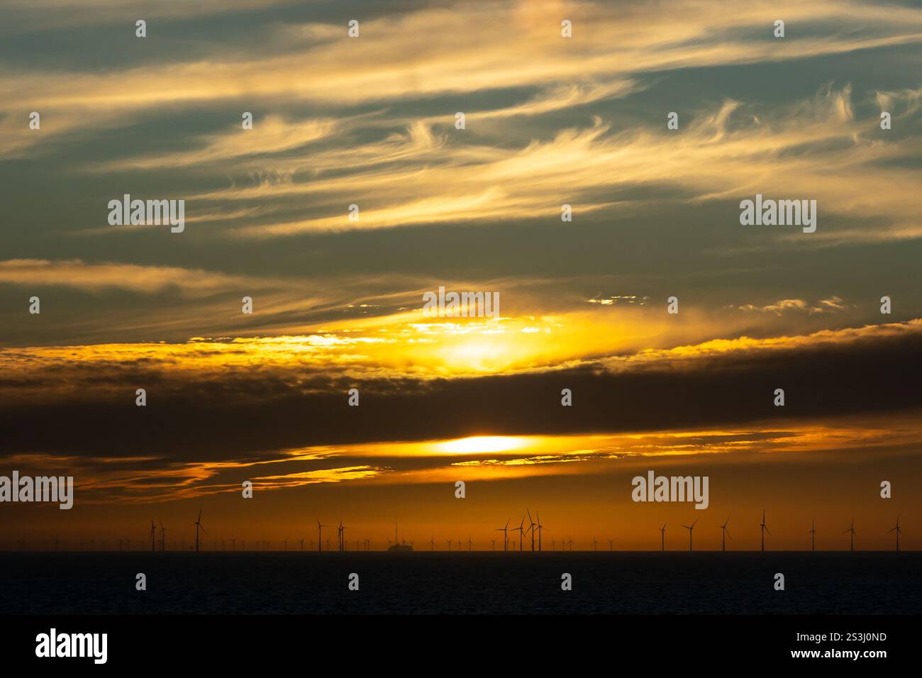 A stunning sunset paints the sky with warm colors above the North Sea ...