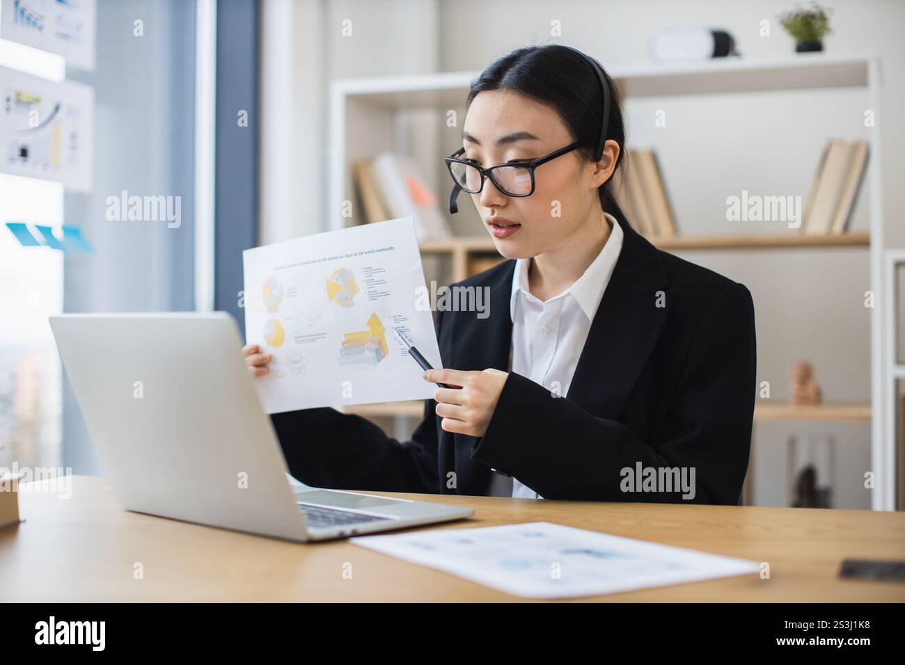 Asian female professional in formal attire conducts online meeting ...