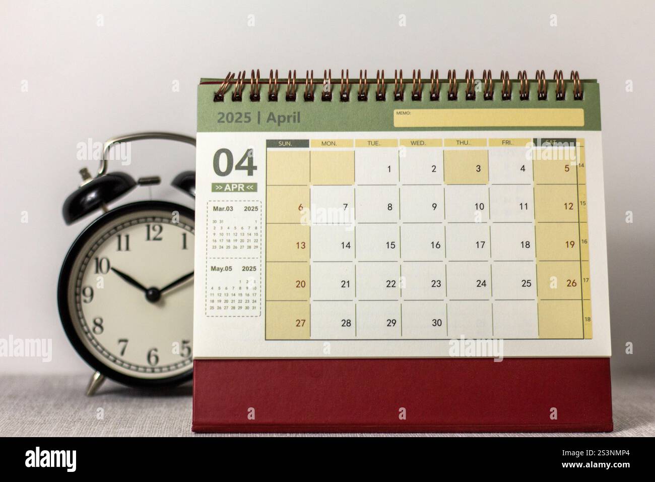 Alarm clock and desktop calendar for April 2025 for planning on your ...