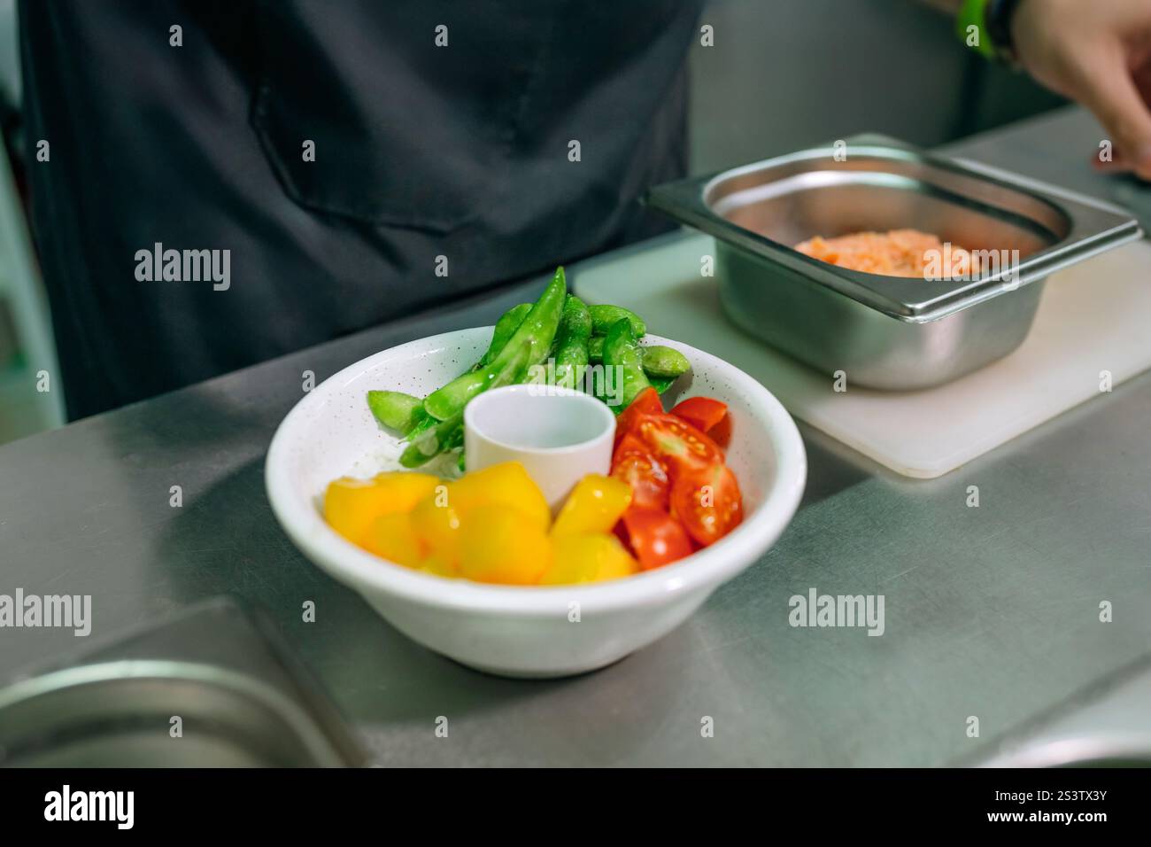 Close up of unrecognizable male chef is preparing a colorful poke bowl ...