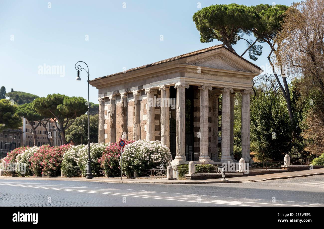 A well preserved Roman temple, in Rome, with colorful flowers around ...