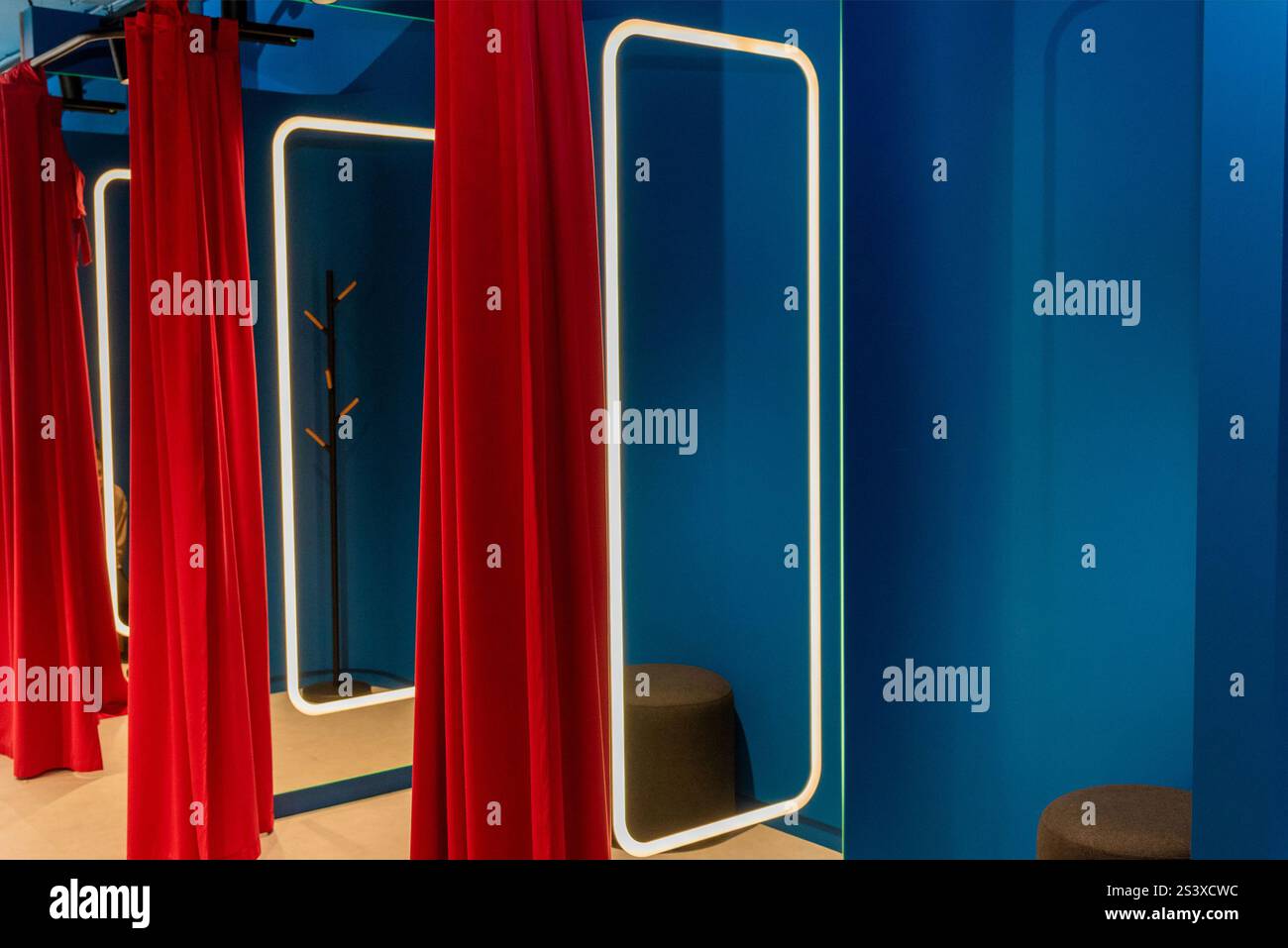 Fitting room in a stylish clothing store, dress room with red curtains ...
