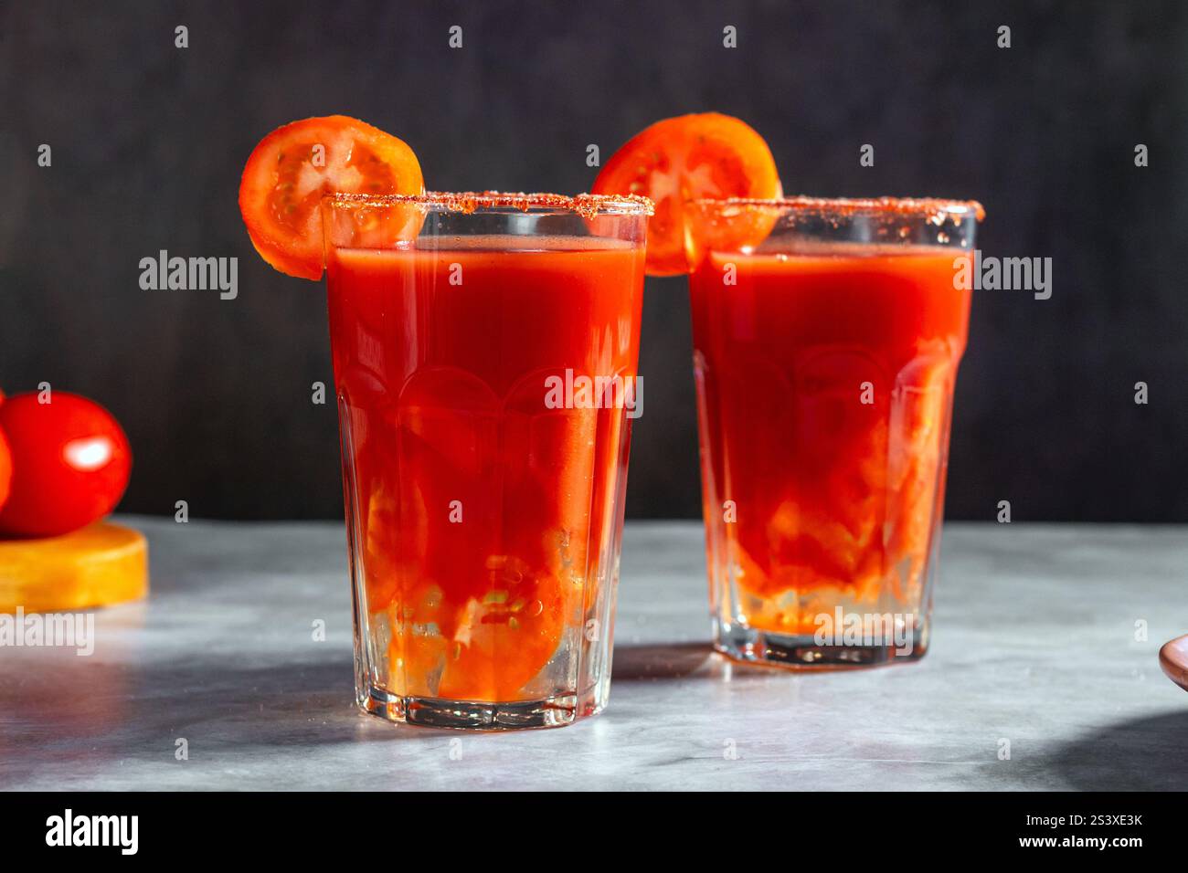 Two Bloody Mary cocktails in glass served with tomato slice and salt on ...