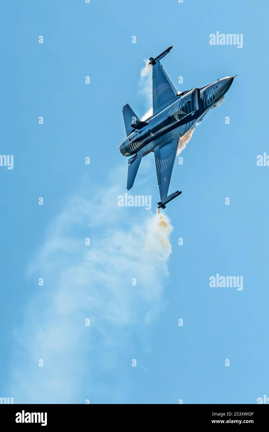 fighter jet soaring through a clear blue sky, captured in an upward ...