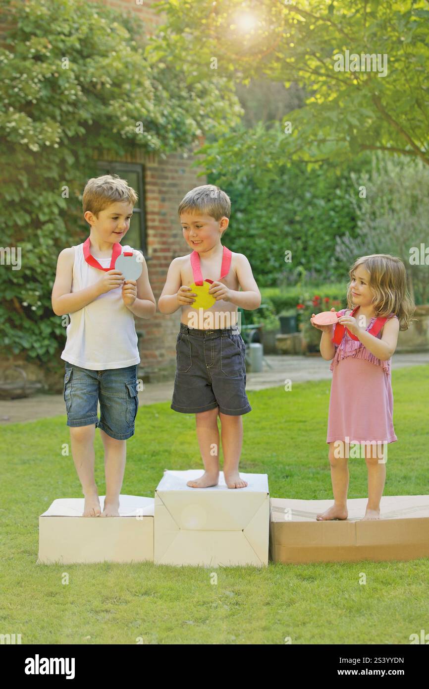 Children Standing on Cardboard Podium with Medals Stock Photo - Alamy