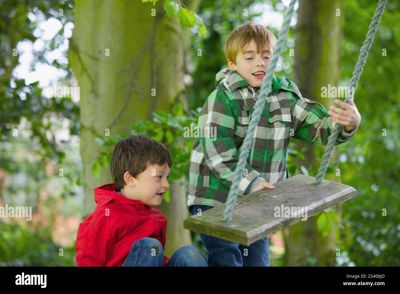 Two Boys Playing on a Swing Stock Photo - Alamy