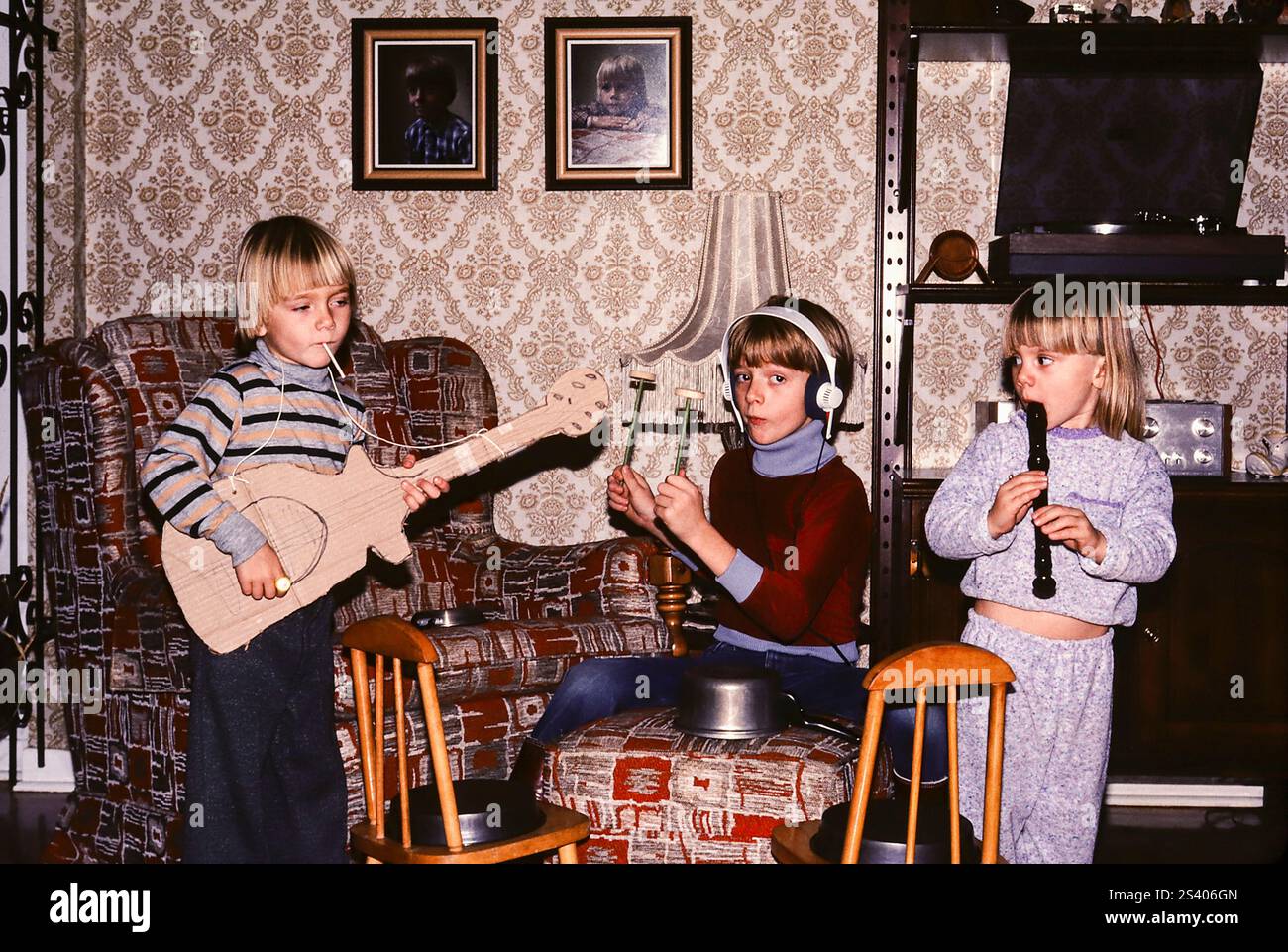 Brothers and sister playing musical instruments in living room Stock ...